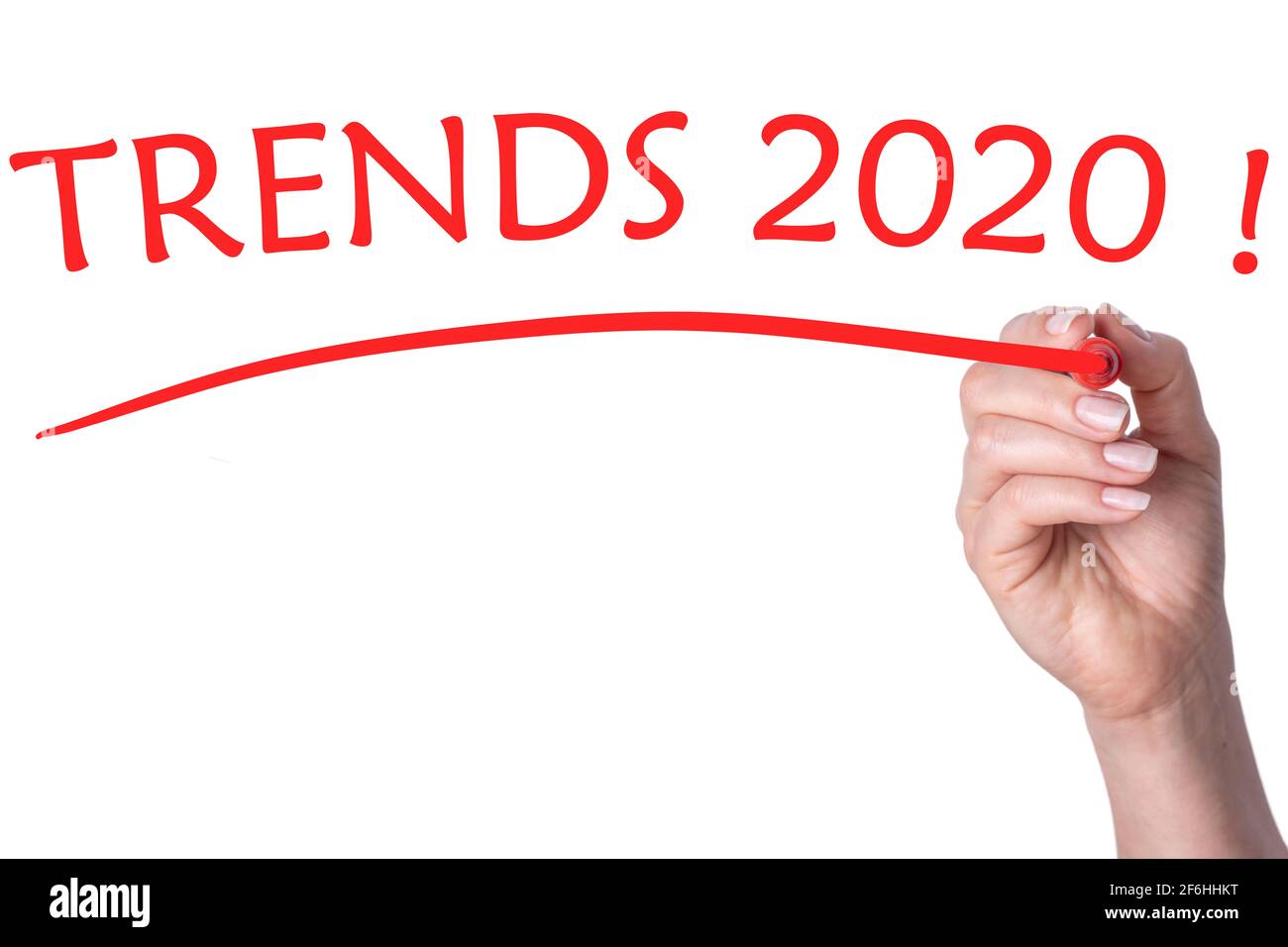 Hand writes word trends 2020 with red marker on transparent white ...