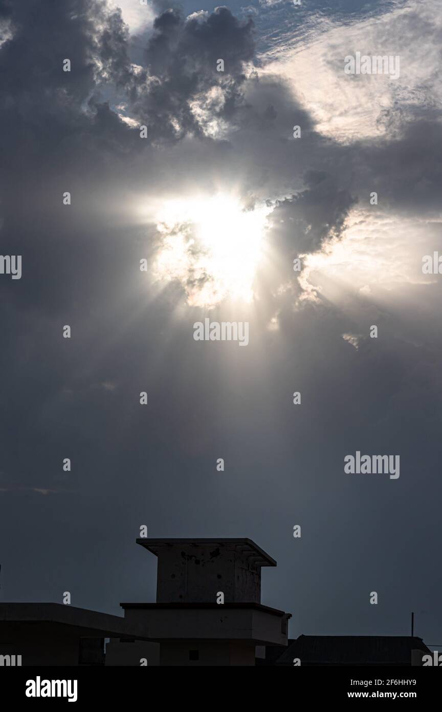 bright sunlight sun shining through hole of clouds over the building ...
