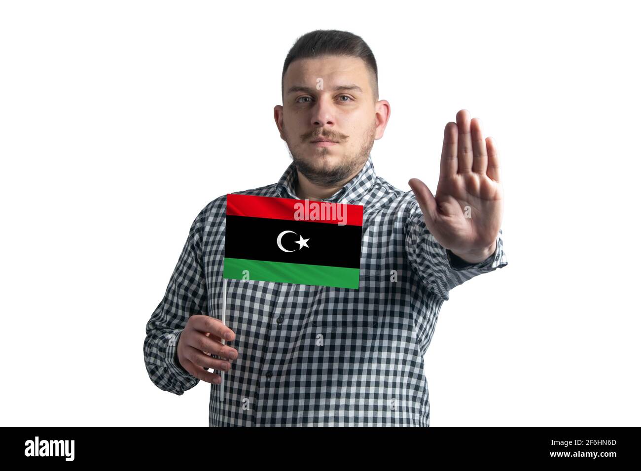 White guy holding a flag of Libya and with a serious face shows a hand ...