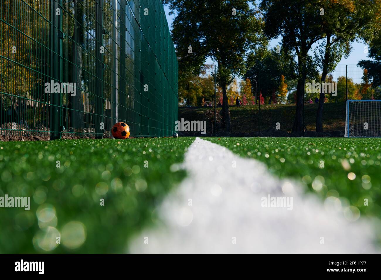 Artificial empty football field with an orange ball. Shallow depth of ...