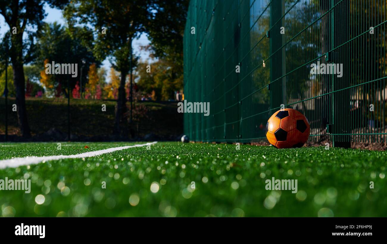 Artificial empty football field with an orange ball. Shallow depth of ...