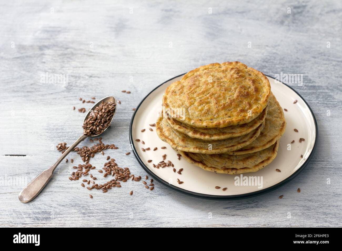 Vegan pancakes with flax seeds and vegan milk on a white plate on a ...