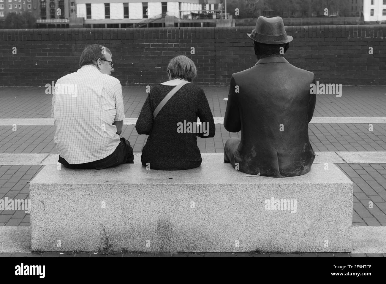 Two humans and a statue Stock Photo - Alamy