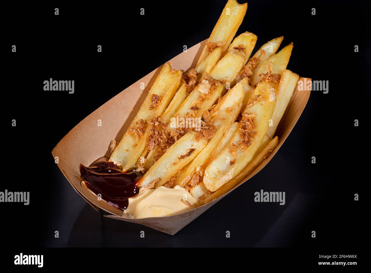 French fries with two sauces in a paper plate. Takeout food. Colored ...