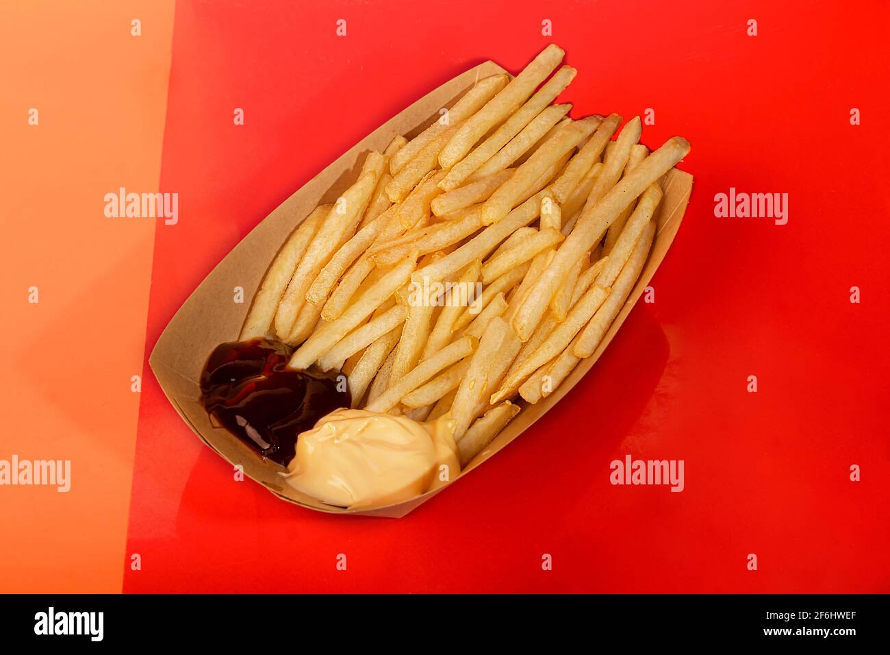 French fries with two sauces in a paper plate. Takeout food. Colored ...