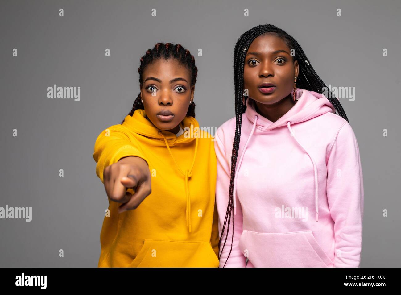 Two young african women are scared about something pointing fingers at ...