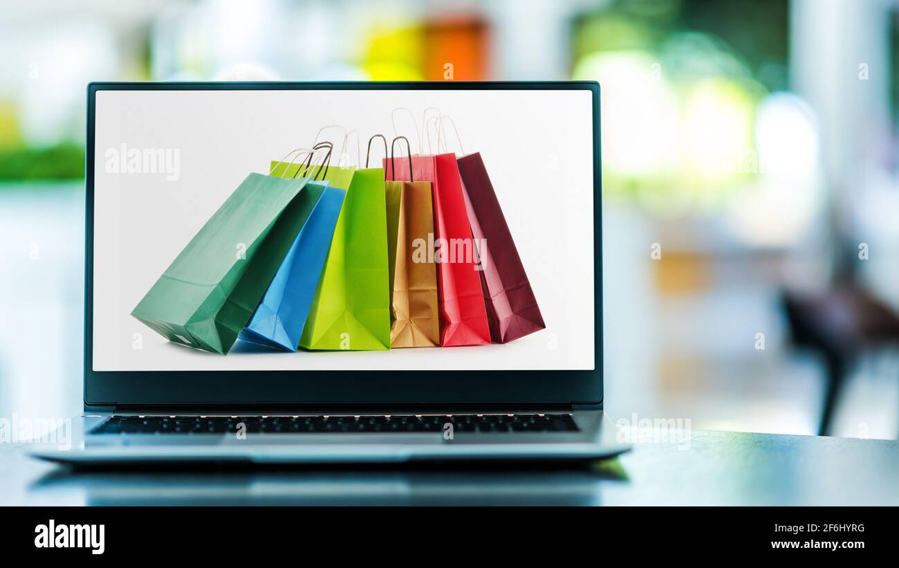 Paper shopping bags on laptop computer screen. Shopping online. E ...