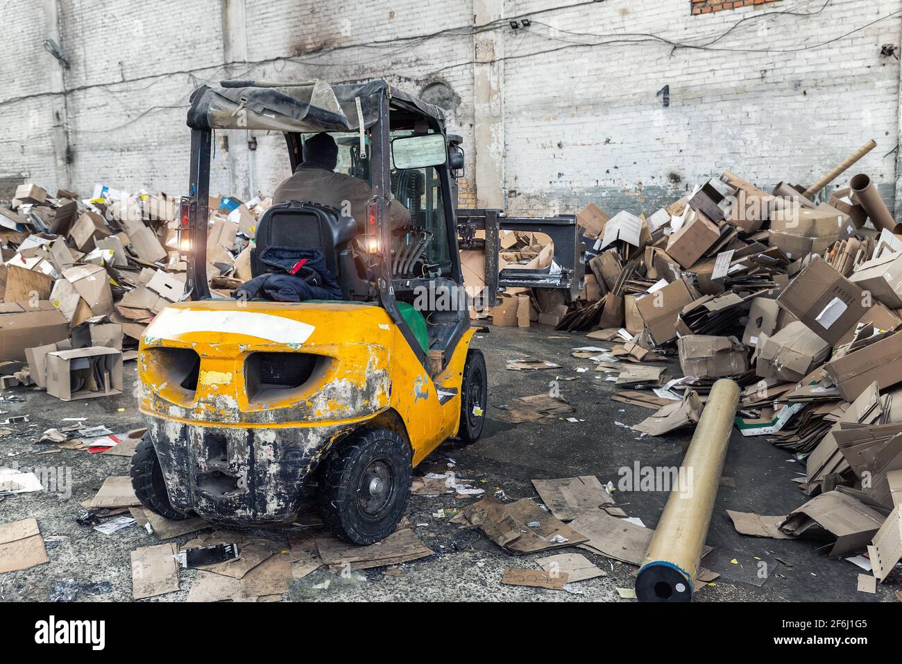 Worker using forklift machine equipment facility at scrap paper ...