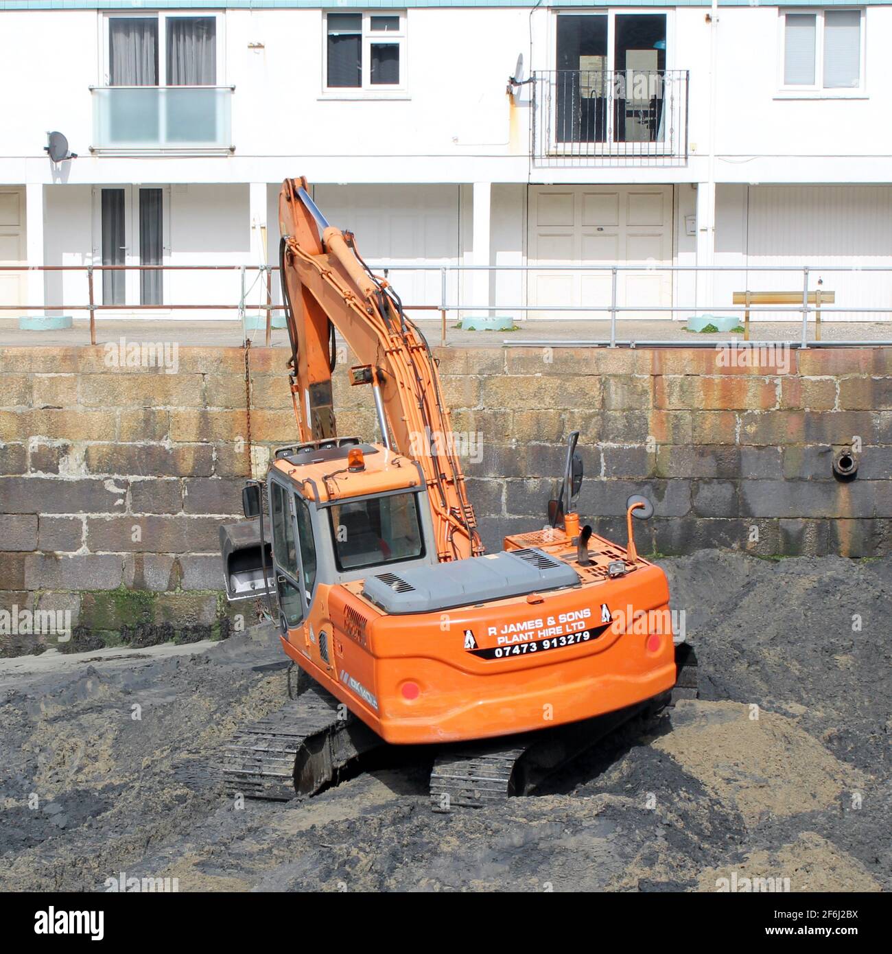 Mechanical digger at work on dredging operations at Portreath Harbour ...