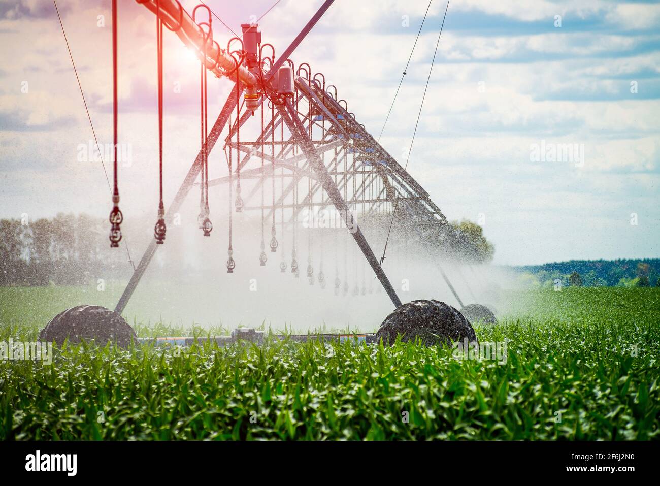 Watering system in the field. An irrigation pivot watering a field ...