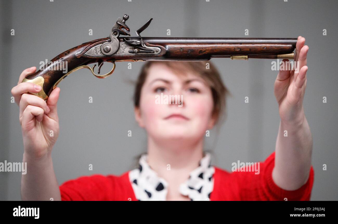 Tennants Auctioneers' employee Alice Fitton holds a flintlock pistol ...