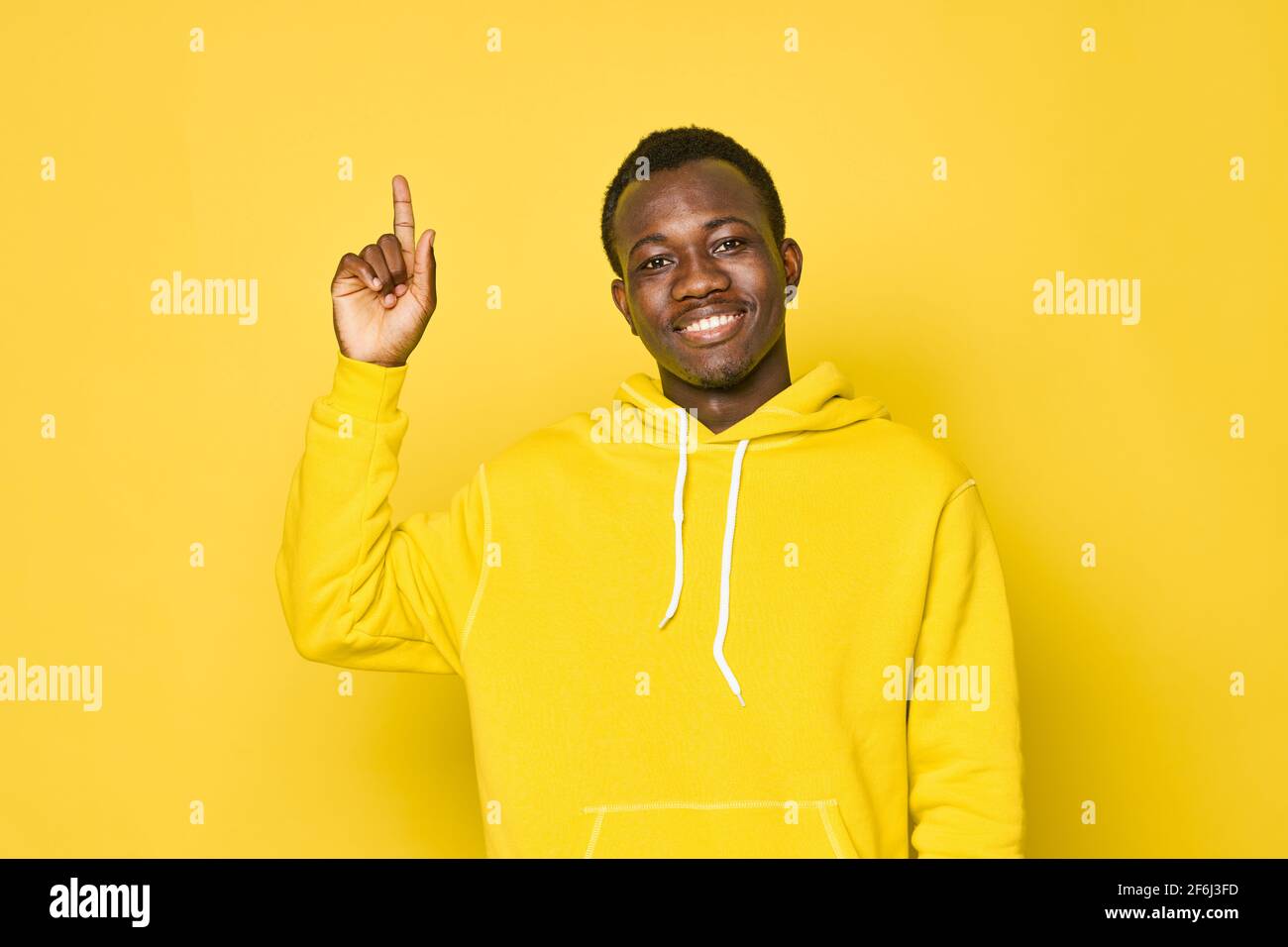 Cheerful man of african appearance yellow jacket hand gesture isolated ...