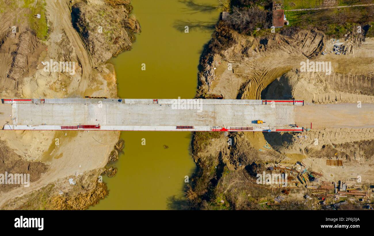 Above top view, overhead, on unfinished bridge, road over river under ...