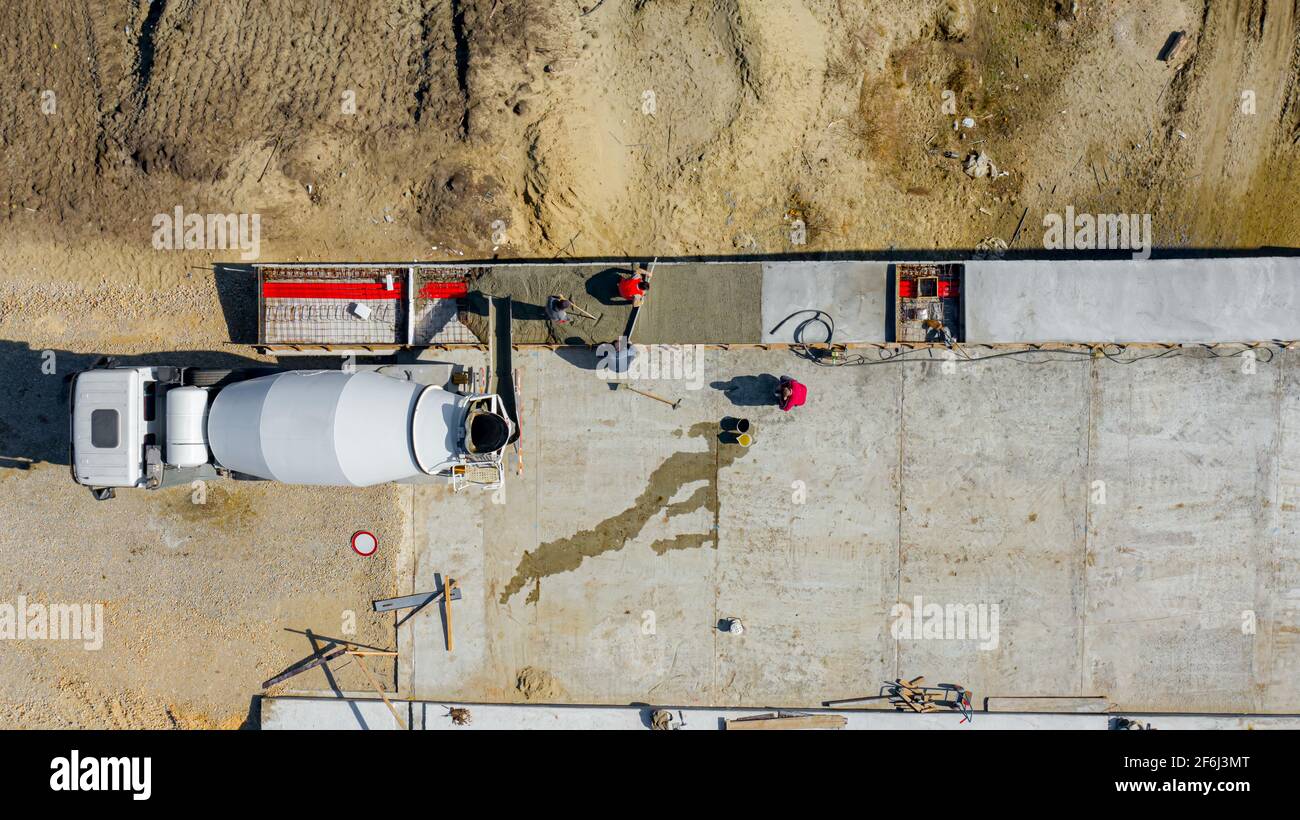 Above top view, overhead on construction workers are using rake to ...