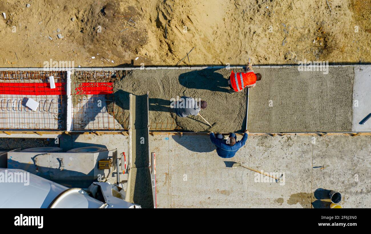 Above top view, overhead on construction workers are using rake to ...