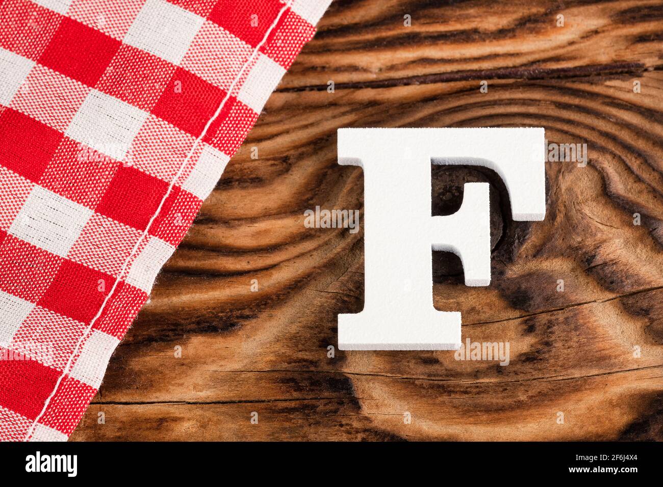 Letter F of the alphabet - Red checkered cloth tablecloth on rustic ...