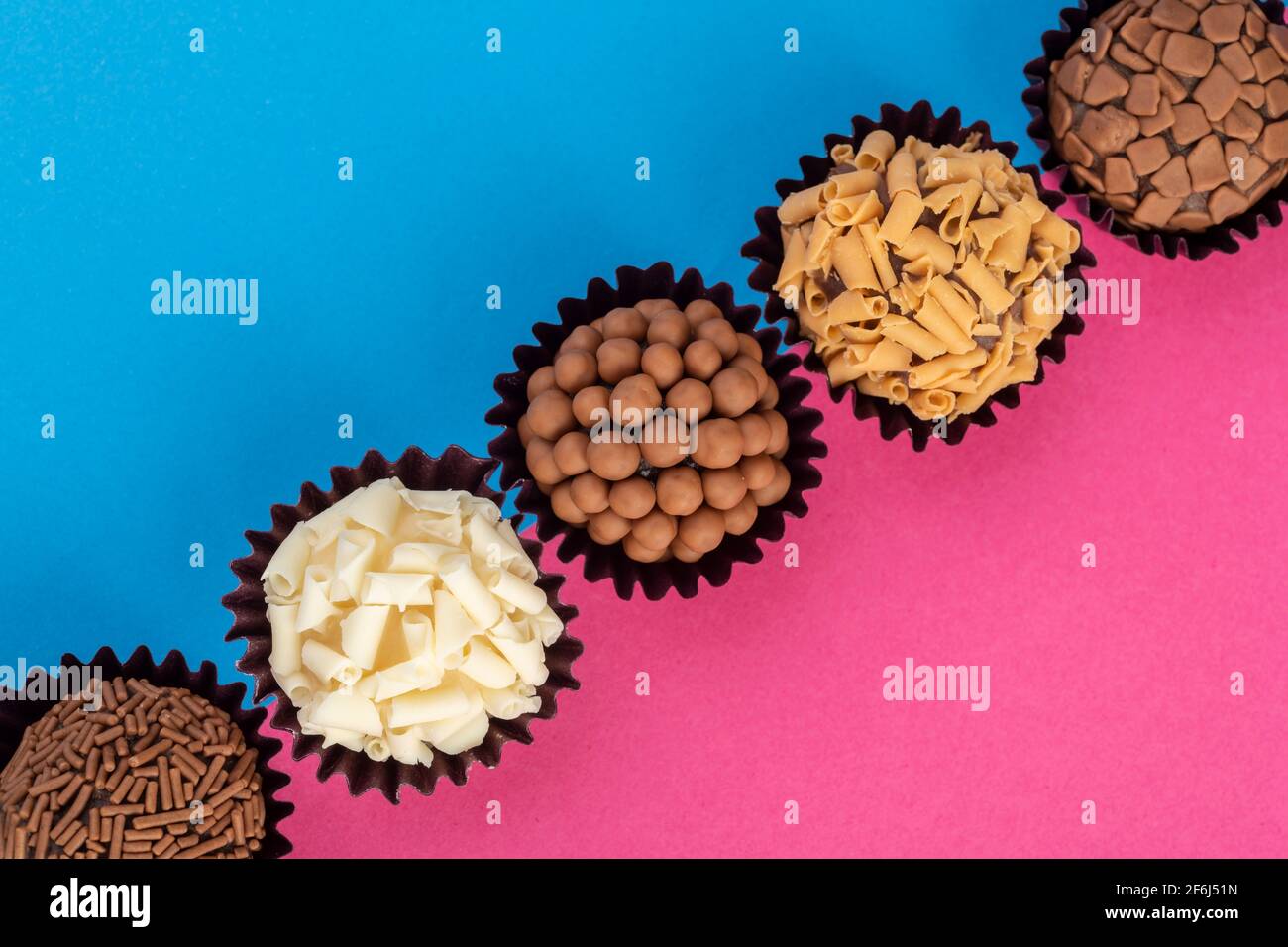 Typical brazilian brigadeiros, various flavors over colorful background ...