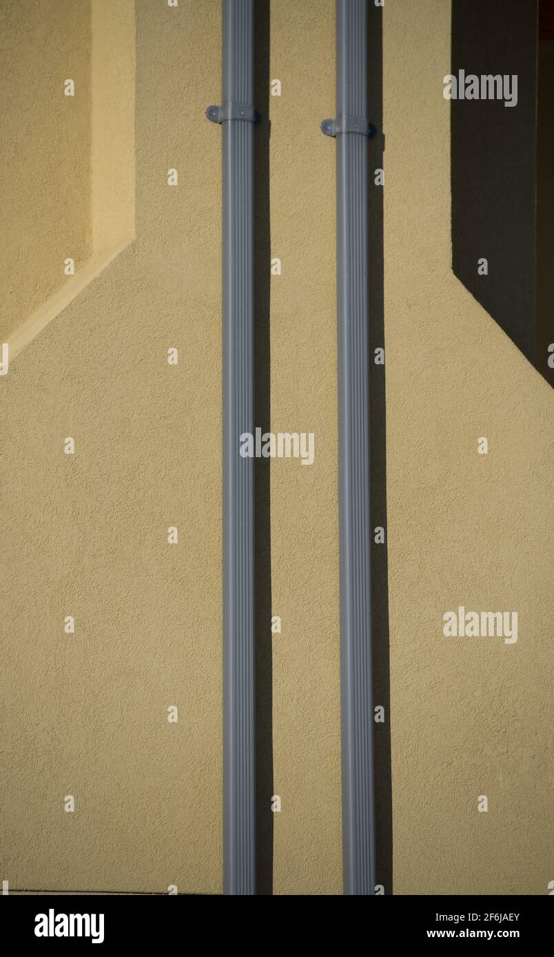 yellow concrete home exterior wall divided by two vertical lines of ...