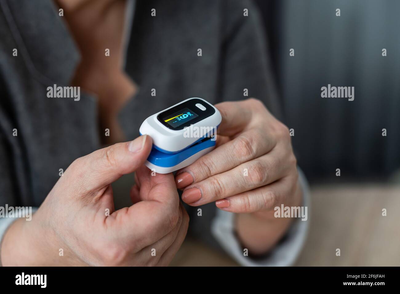 Old lady measuring her oxygen saturation with a pulse oximeter. Health ...