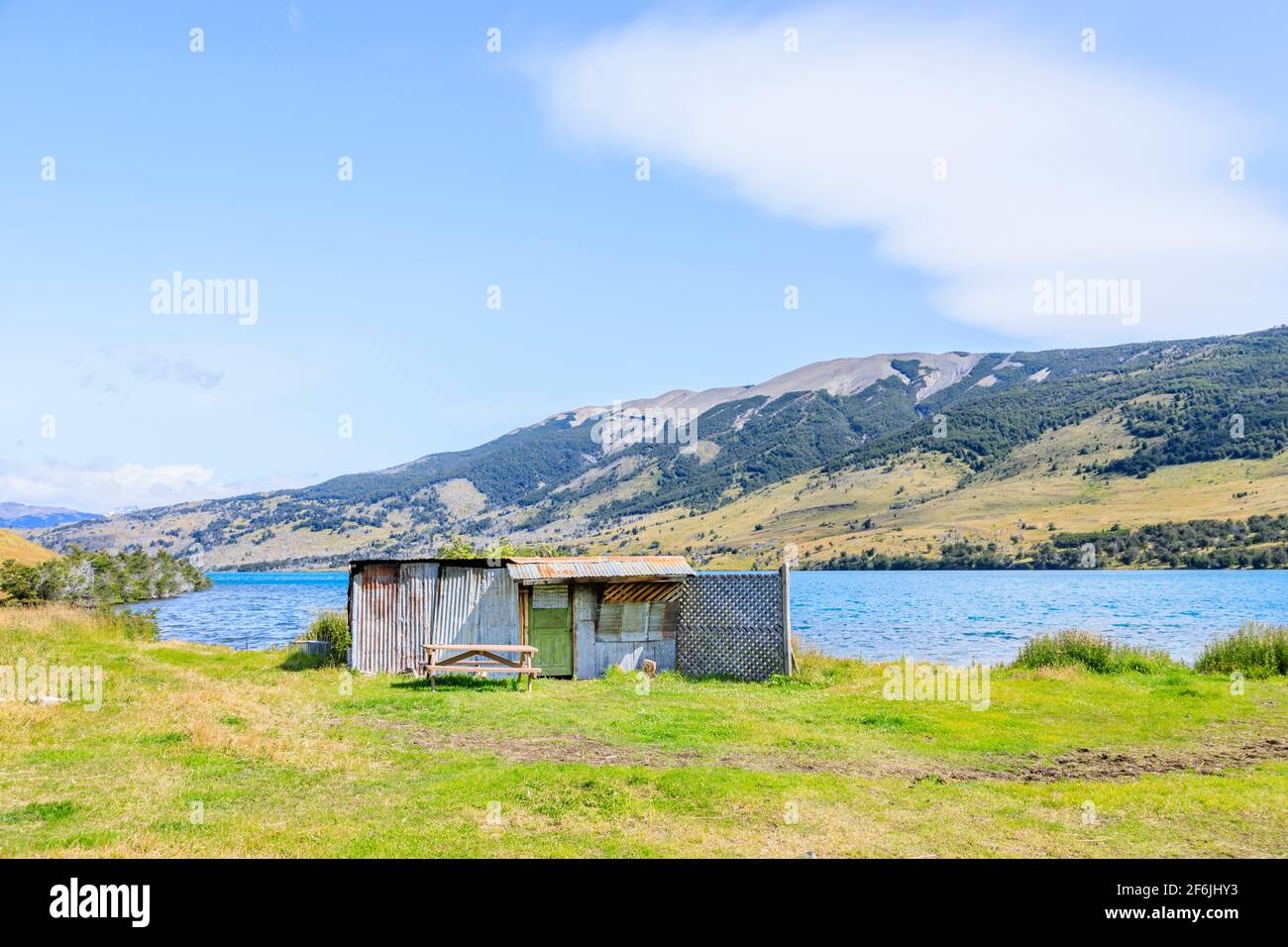 Small boarded up corrugated iron refuge hut on the shore of Laguna Azul ...