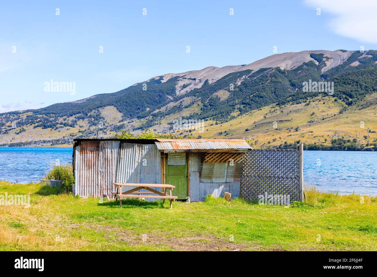 Small boarded up corrugated iron refuge hut on the shore of Laguna Azul ...