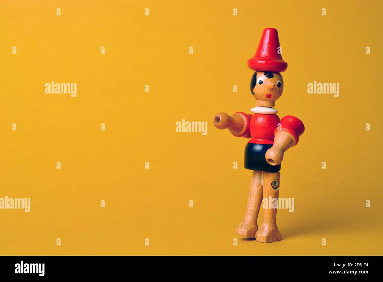 Wooden puppet depicting Pinocchio walking on a yellow background Stock ...