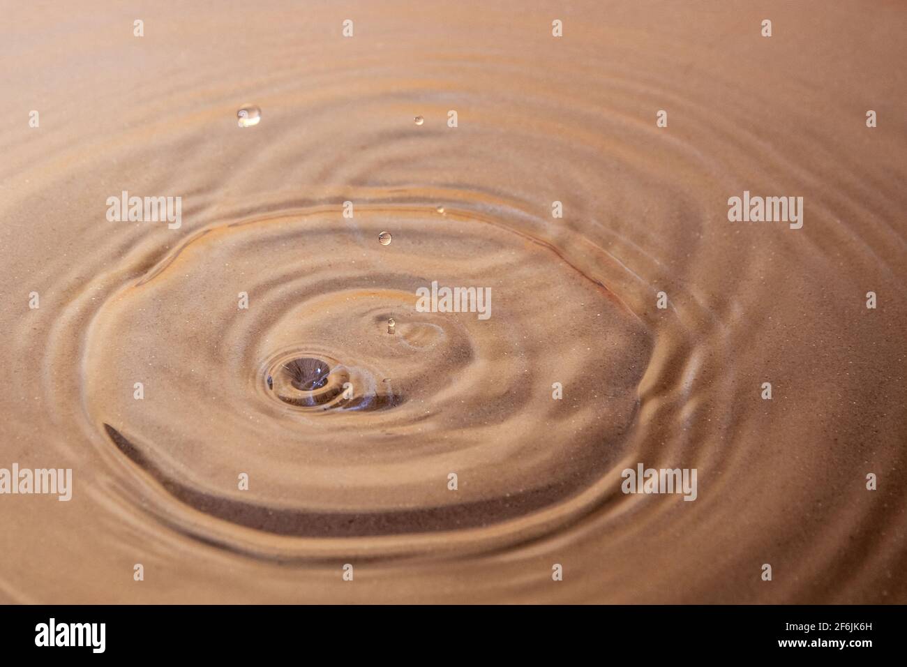 Clear water in shallow sea water. Circles spread out on its surface ...