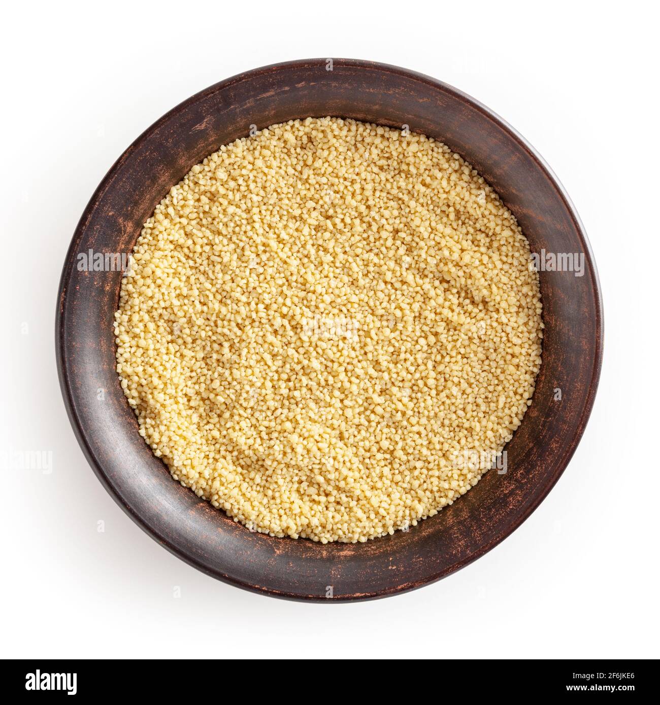 Uncooked couscous in handmade ceramic bowl isolated on white background ...