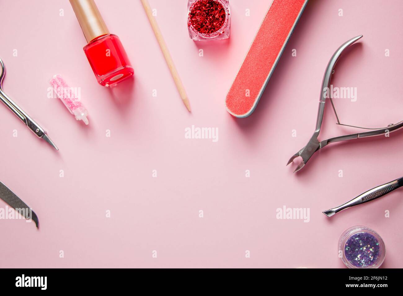 A set of tools for manicure and nail care on a pink background ...