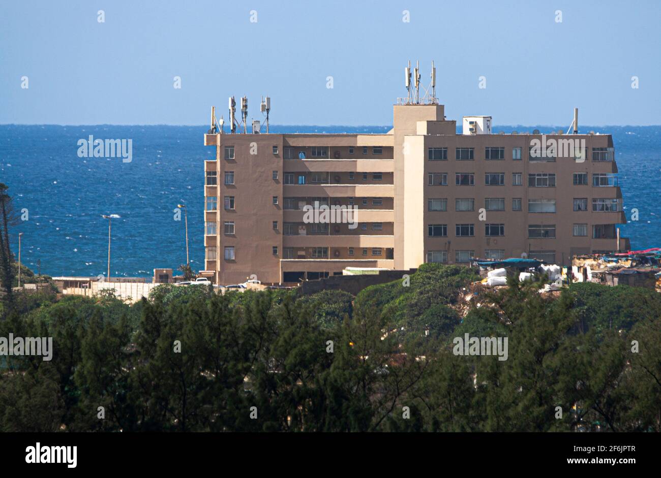 View of tall residential building against deep blue sea Stock Photo - Alamy