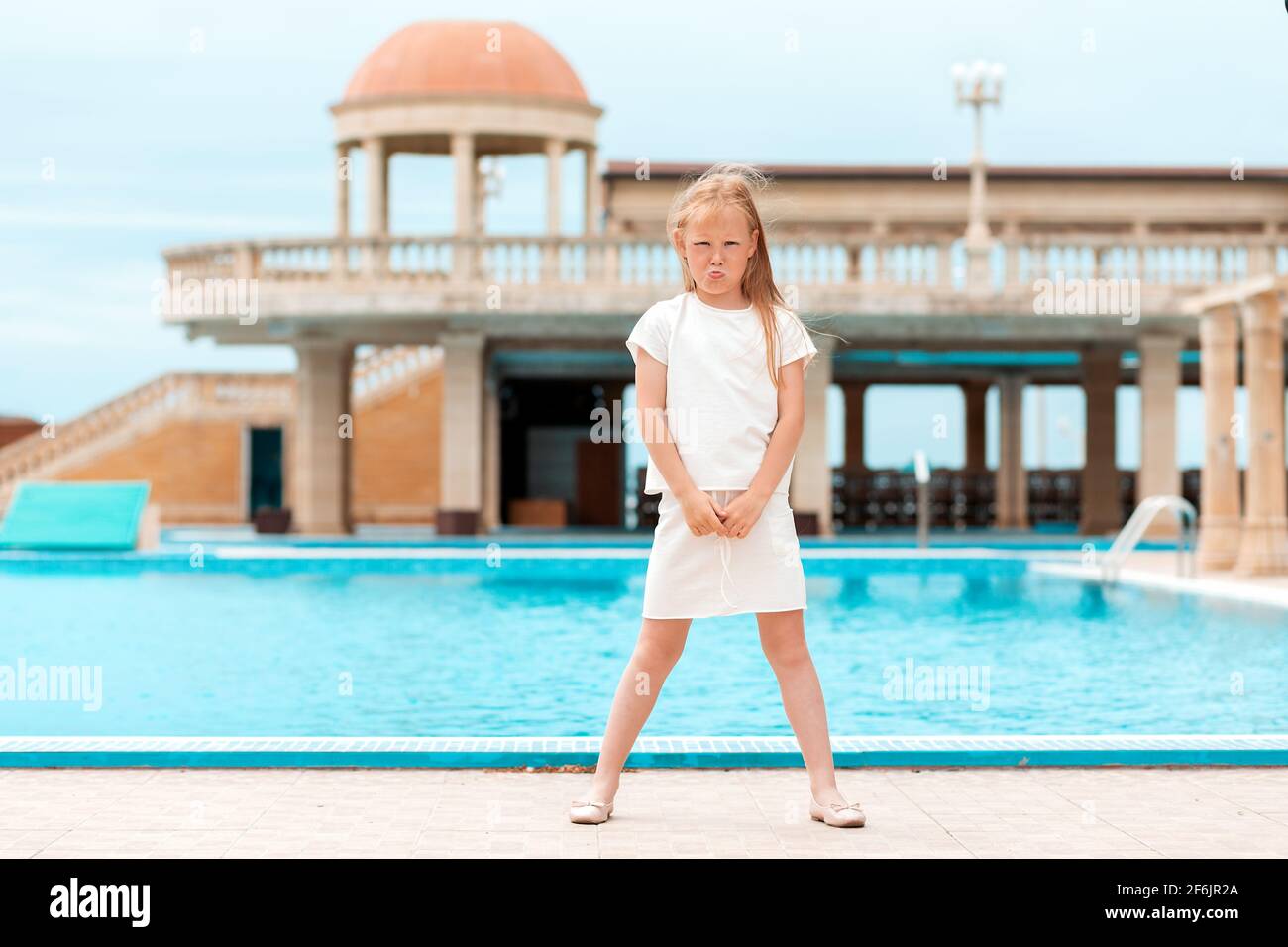 Childrens whims. A sad little girl standing by the pool. Concept of ...