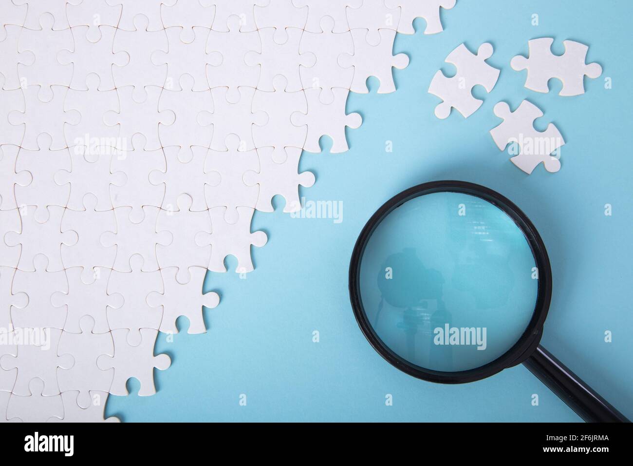 Set of puzzle pieces with magnifying glass background. Detective ...