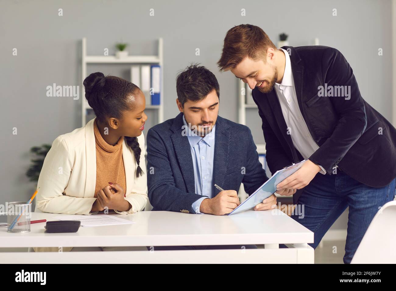 Financial advisor and biracial family couple signing contract agreement ...