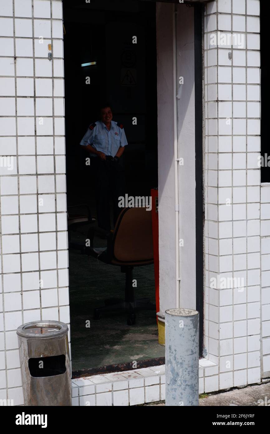 An open door shows a security guard smiling in an industrial building ...