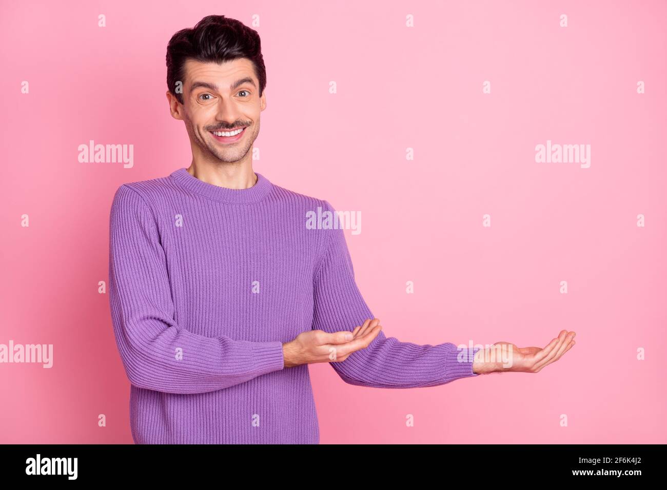 Photo of funny charming young man dressed purple pullover holding arms ...