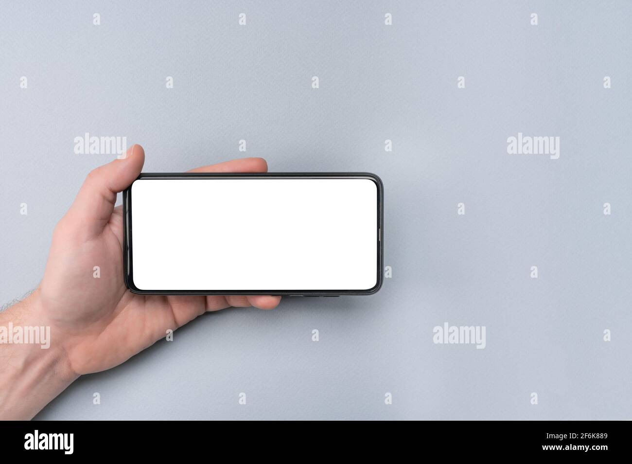 Mockup cell phone. male hand holding phone horizontally with blank ...