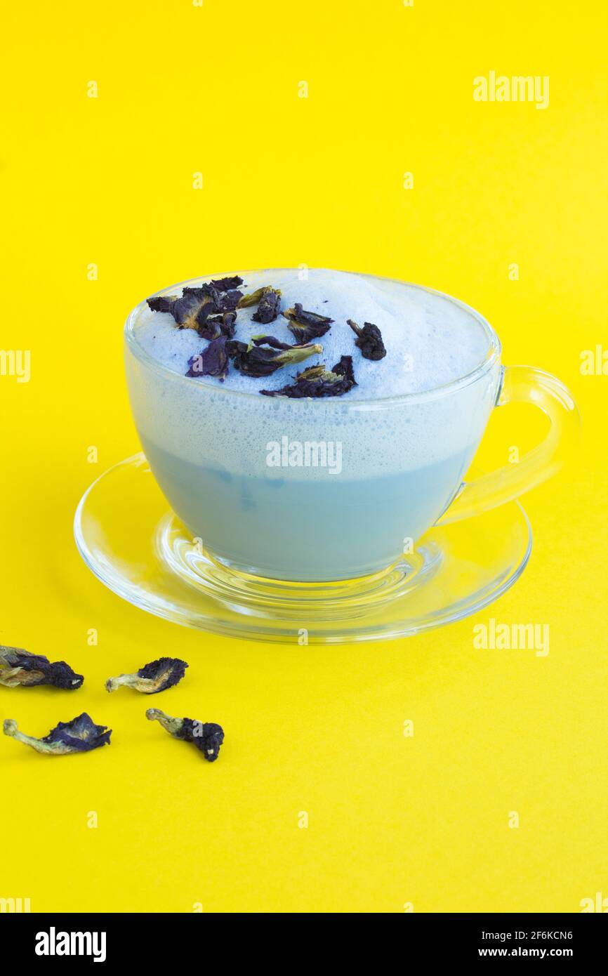 Blue moon milk in glass cup on the yellow surface. Location vertical ...