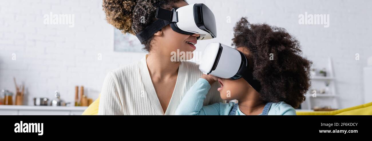 amazed african american child and smiling mother gaming in vr headsets ...