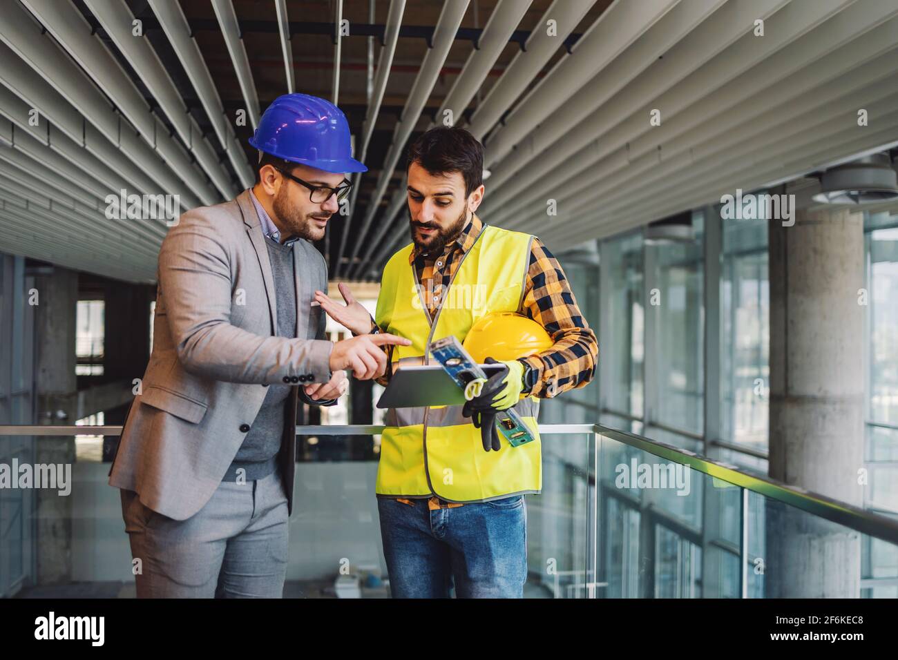 Architect and construction worker standing in building in construction ...