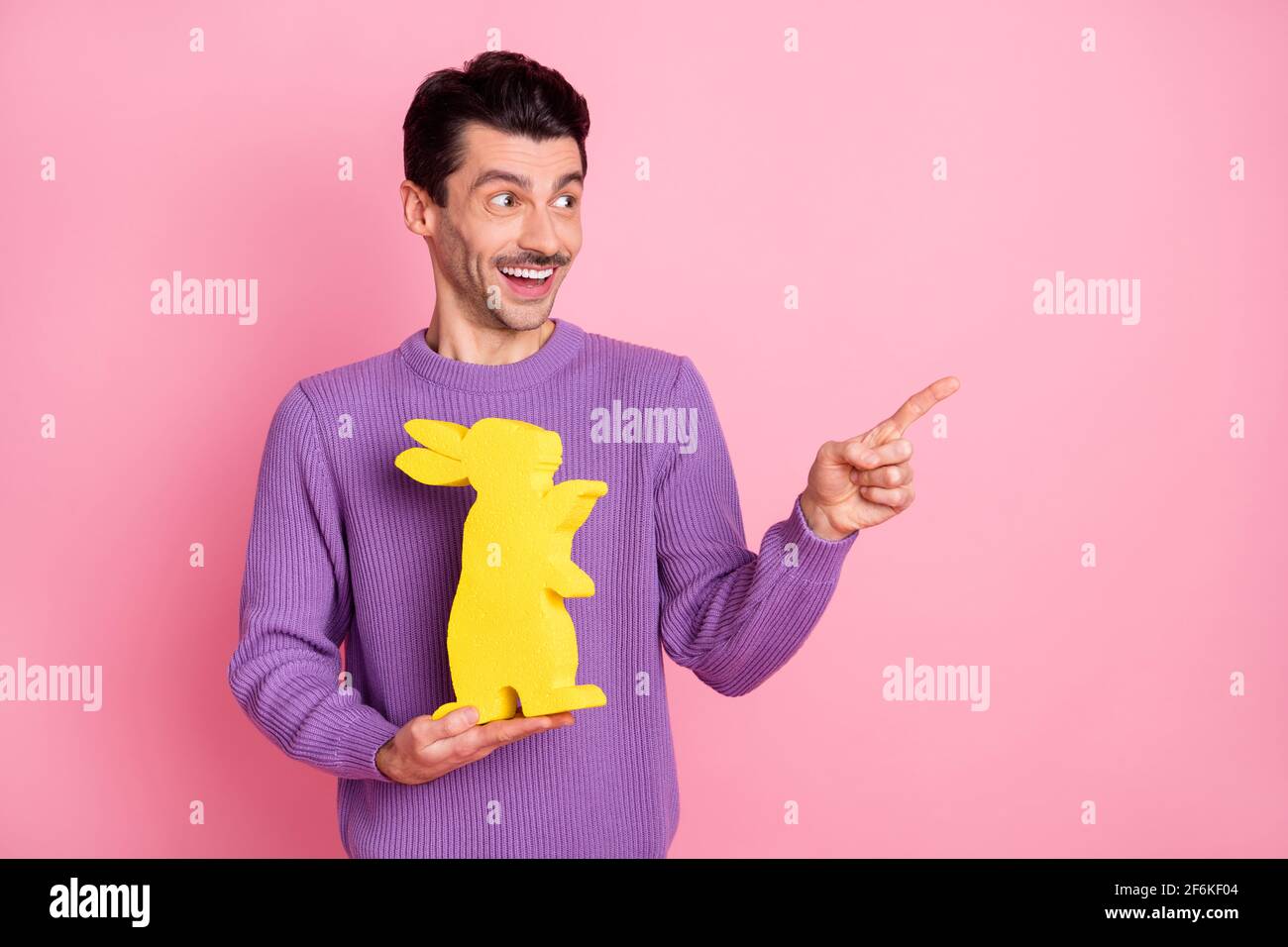 Photo of charming sweet young man dressed purple pullover holding ...