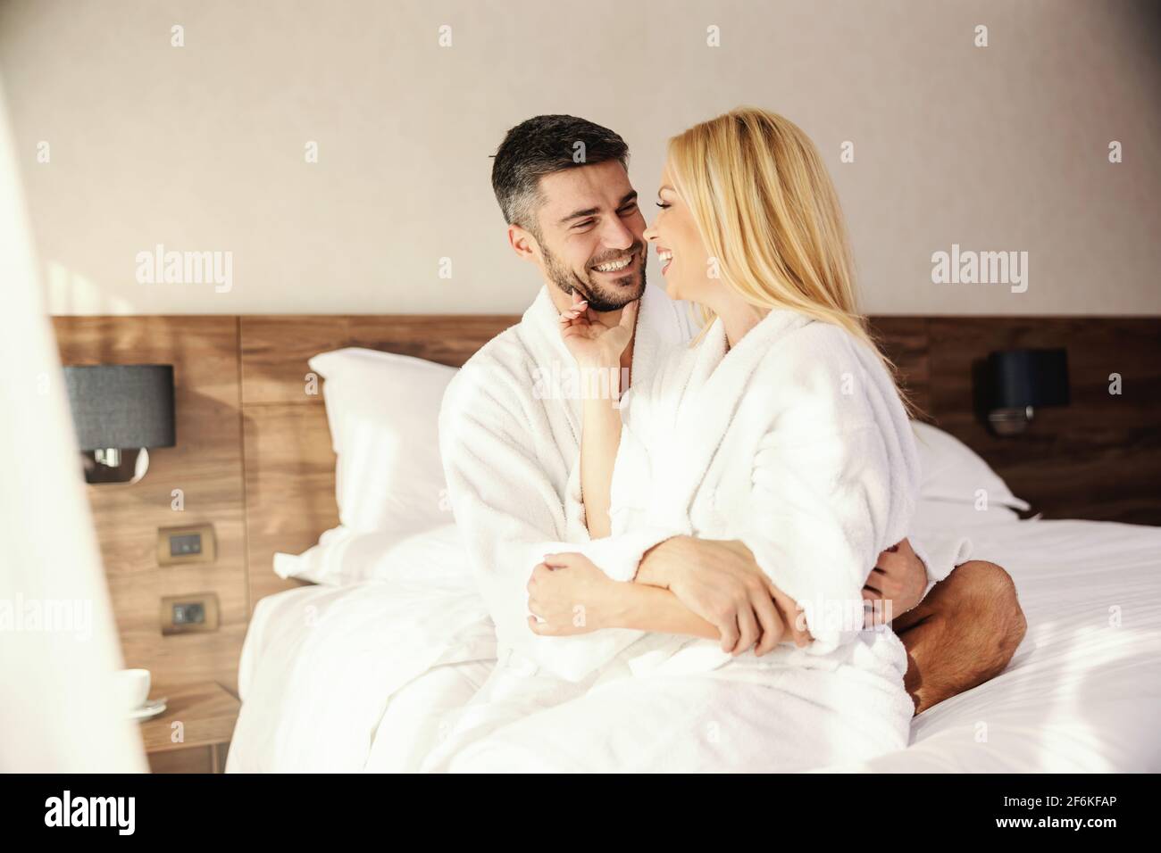 Honeymoon, freshly married couple kissing and tenderness in the warmth ...