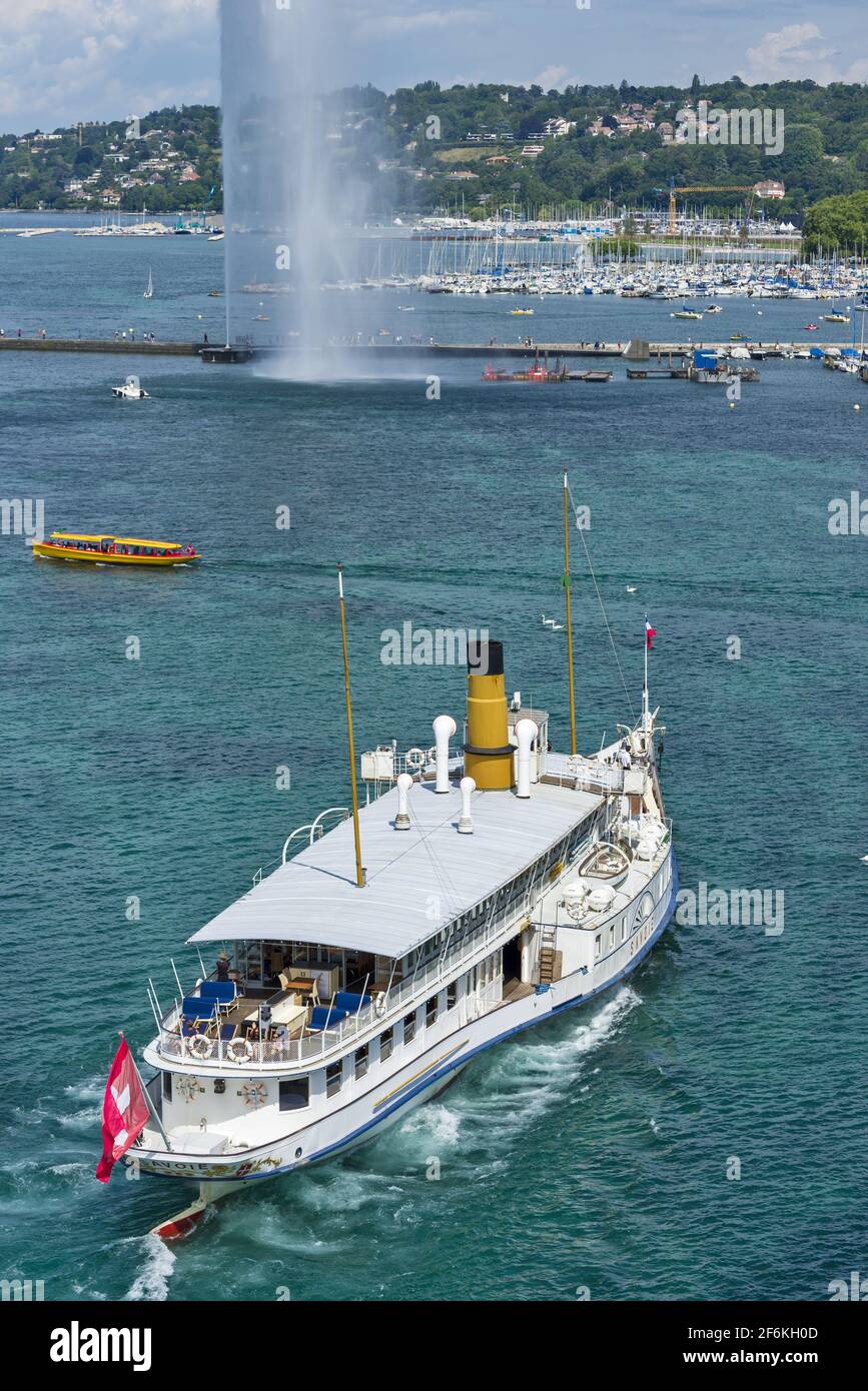vintage steamboat arriving at a pier on Lake Geneva with the water jet ...
