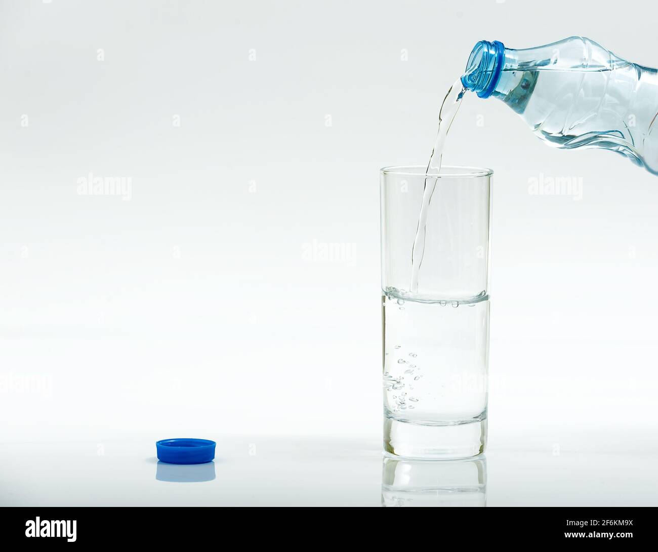 Water bottle pour water to glass on white background Stock Photo - Alamy