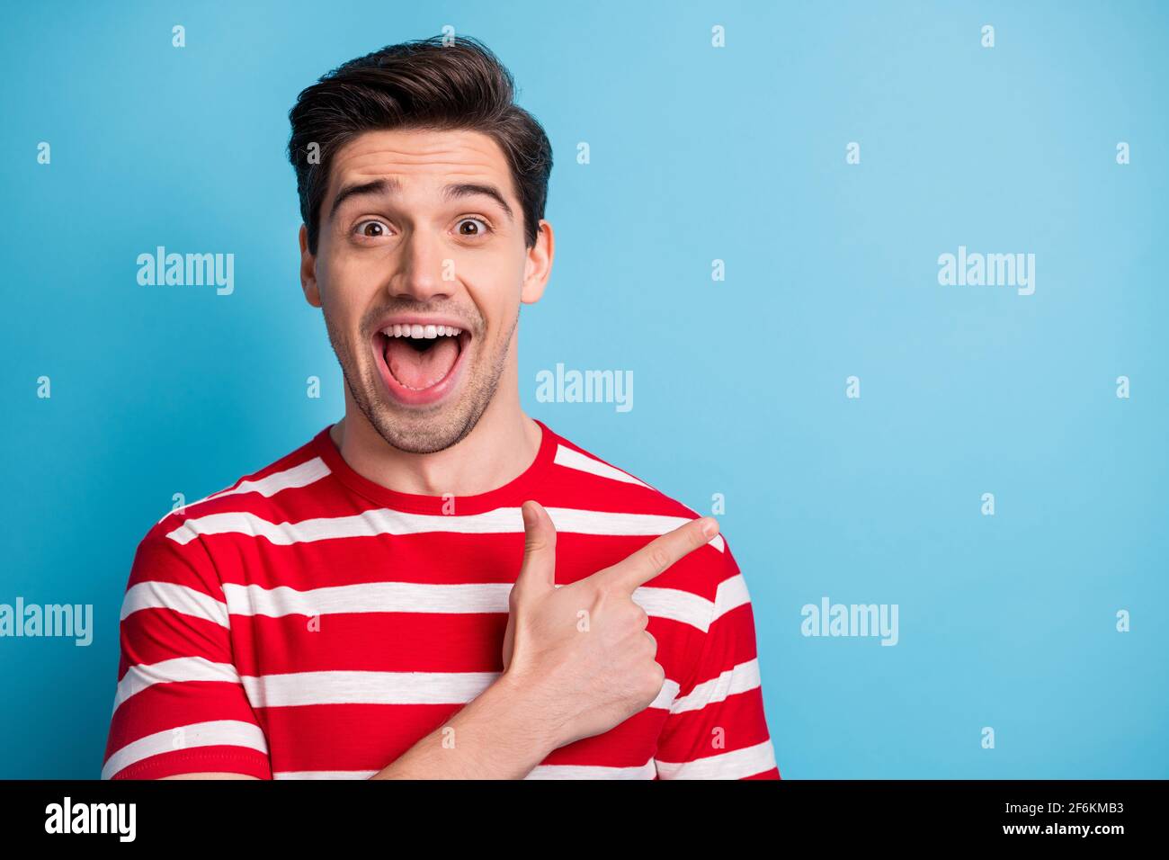 Photo of excited shocked young man point finger empty space discount ...