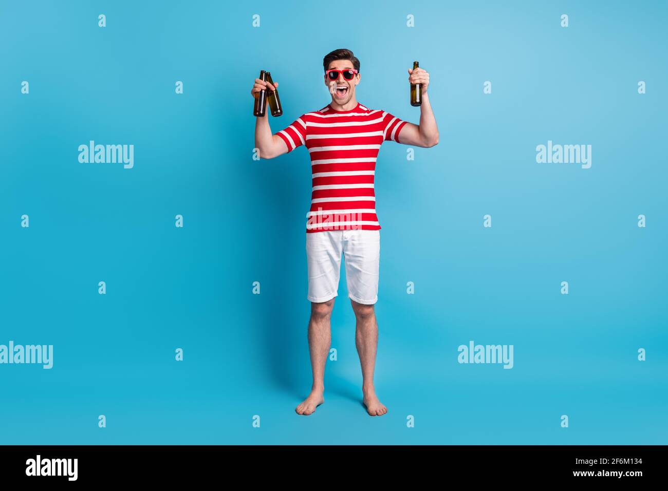 Full length body photo happy man keeping glass beer bottles laughing ...