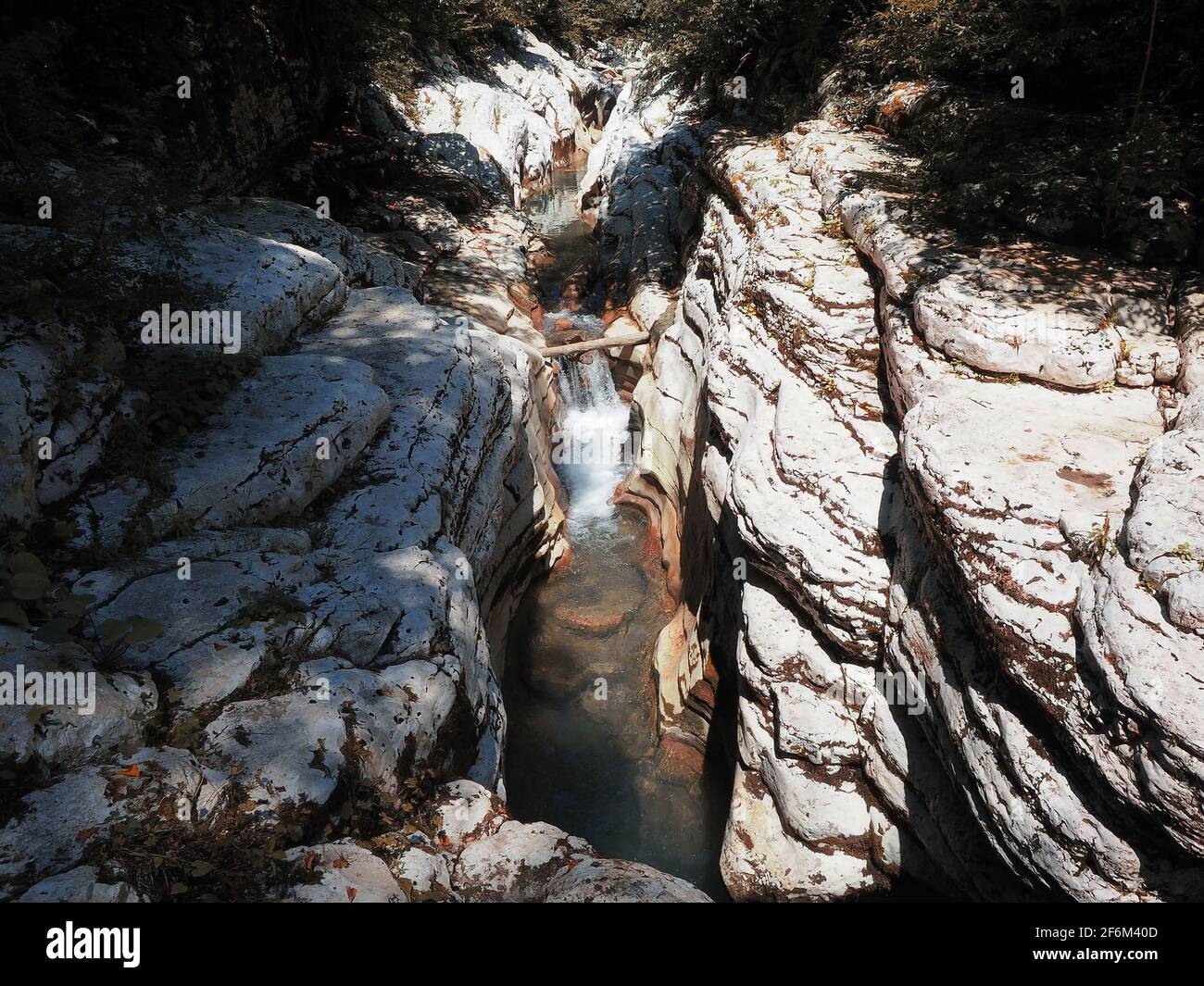 Canyon white cliffs lit by the sun with river flowing between them ...