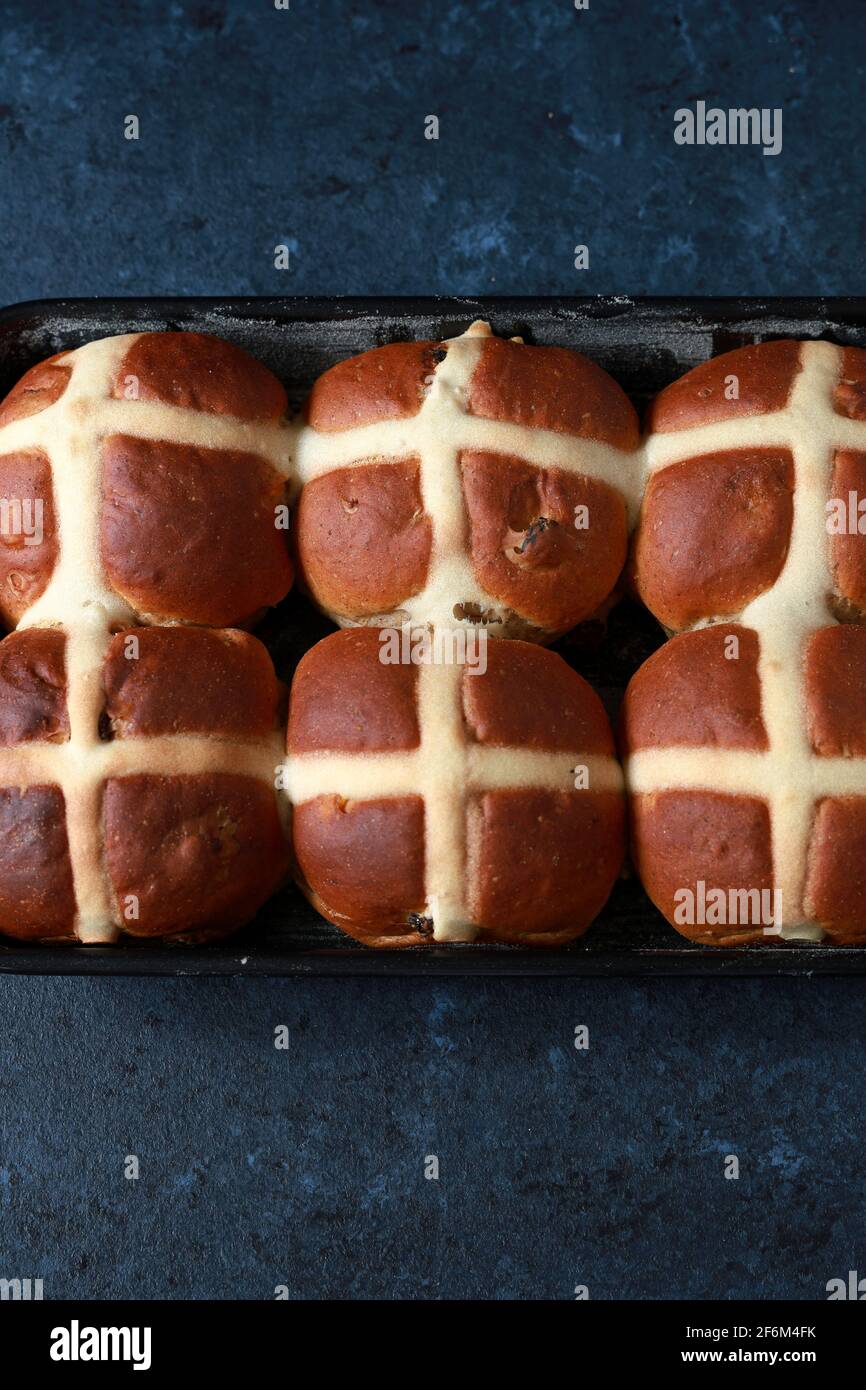 Freshly baked homemade Hot Cross Buns with spices on dark blue ...