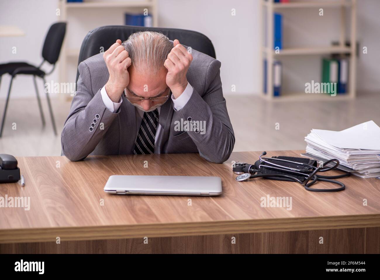 Aged male employee feeling bad in the office Stock Photo - Alamy