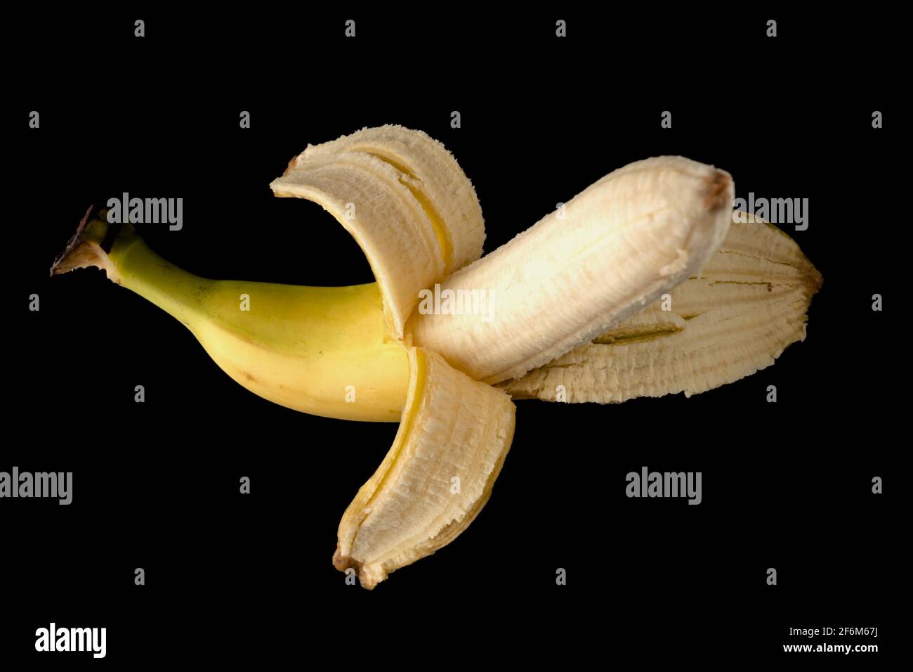 One ripe banana half peeled, on a black background, isolated Stock ...