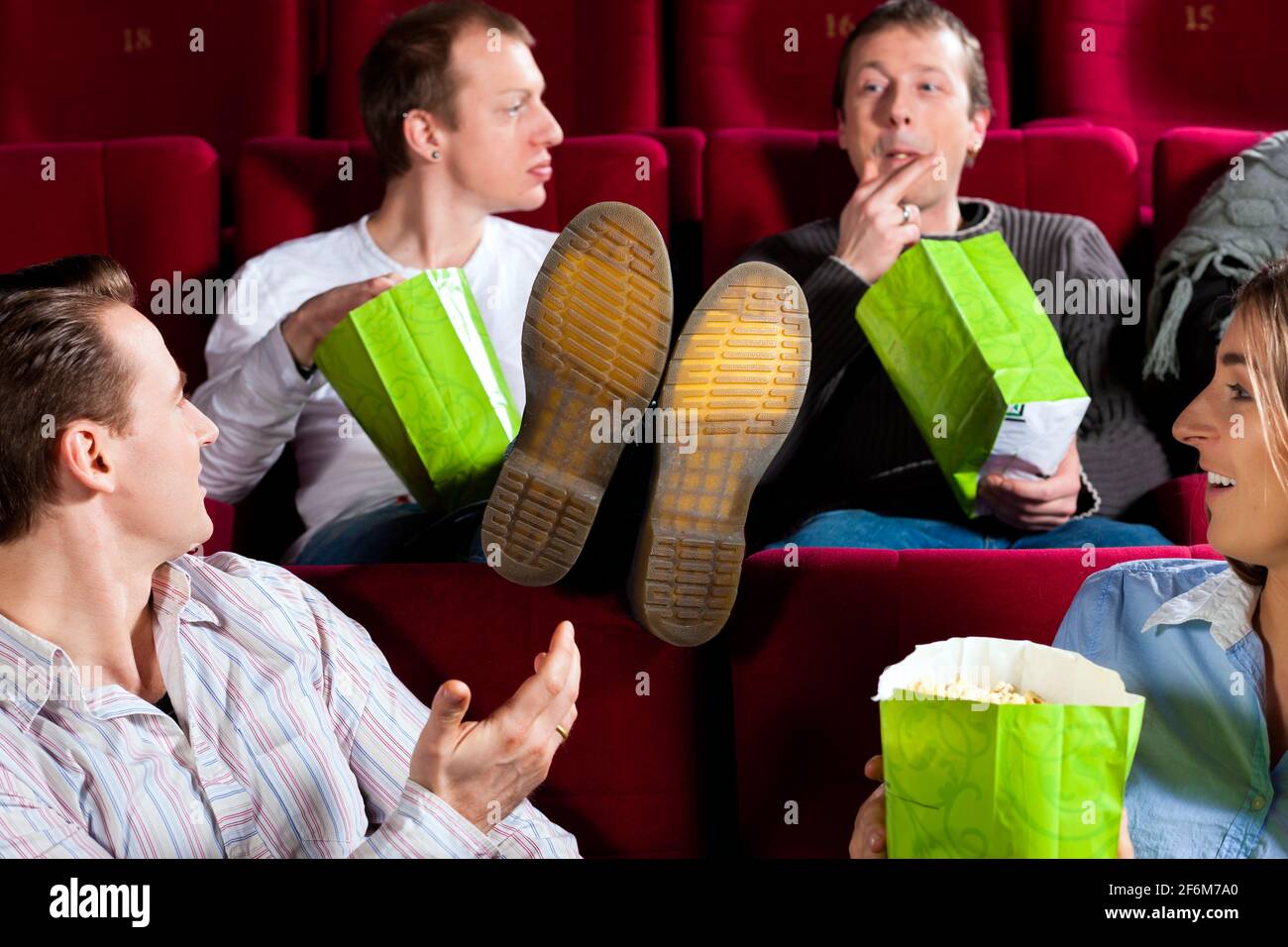 Five people - amongst them a couple - in cinema theater watching a ...